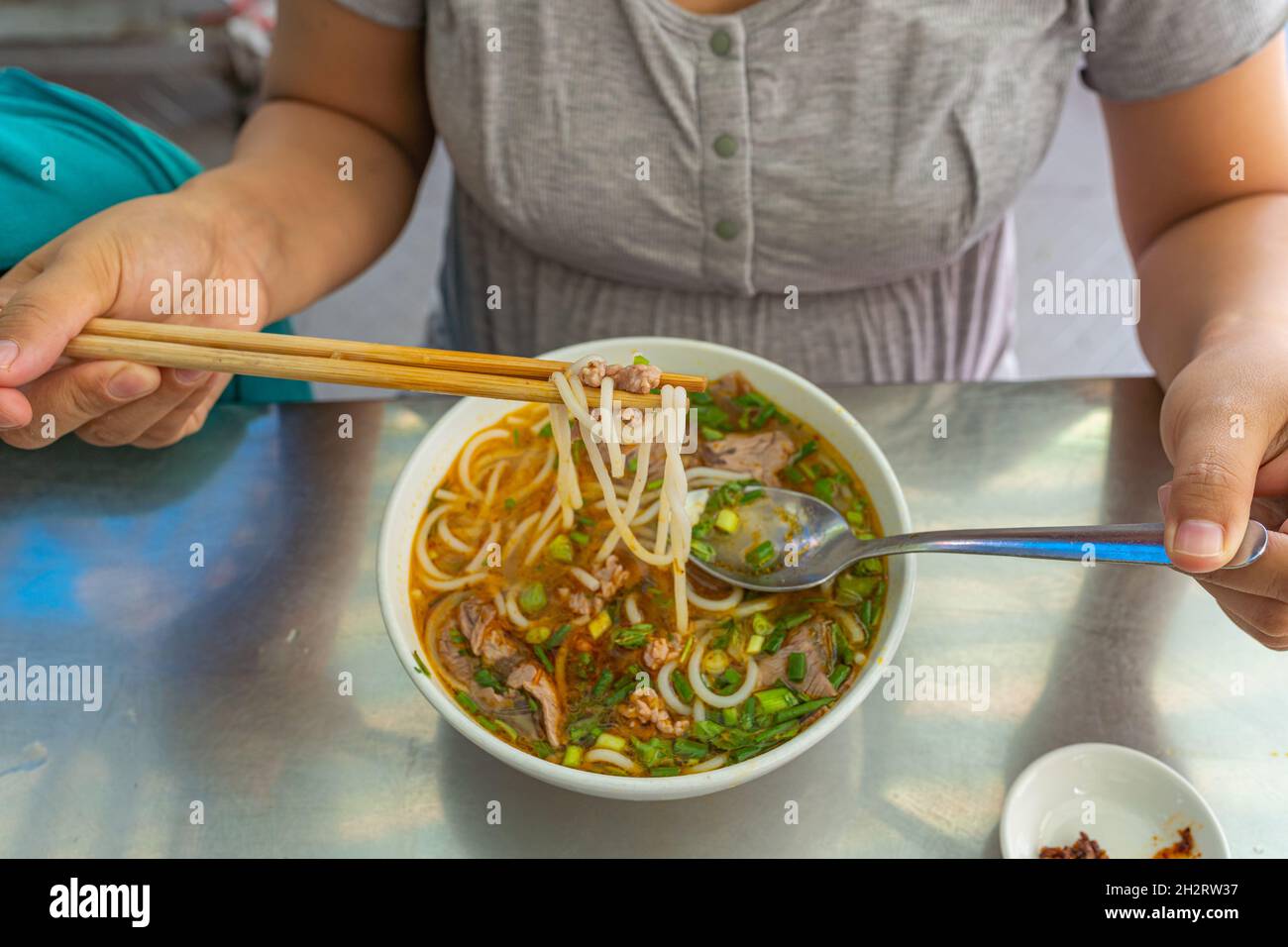 Woman eating Bun Bo Hue, delicious Vietnamese food Stock Photo - Alamy