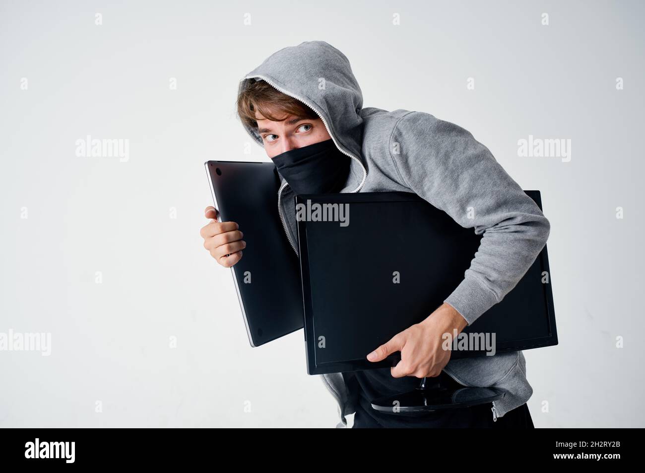 masked man hooded head hacking technology security light background Stock Photo - Alamy