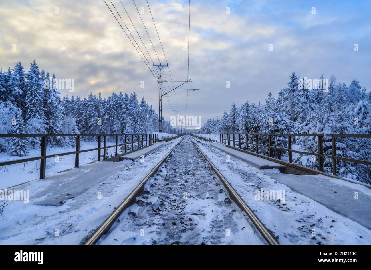 Rail track with snow and forest during sundown hi-res stock photography ...