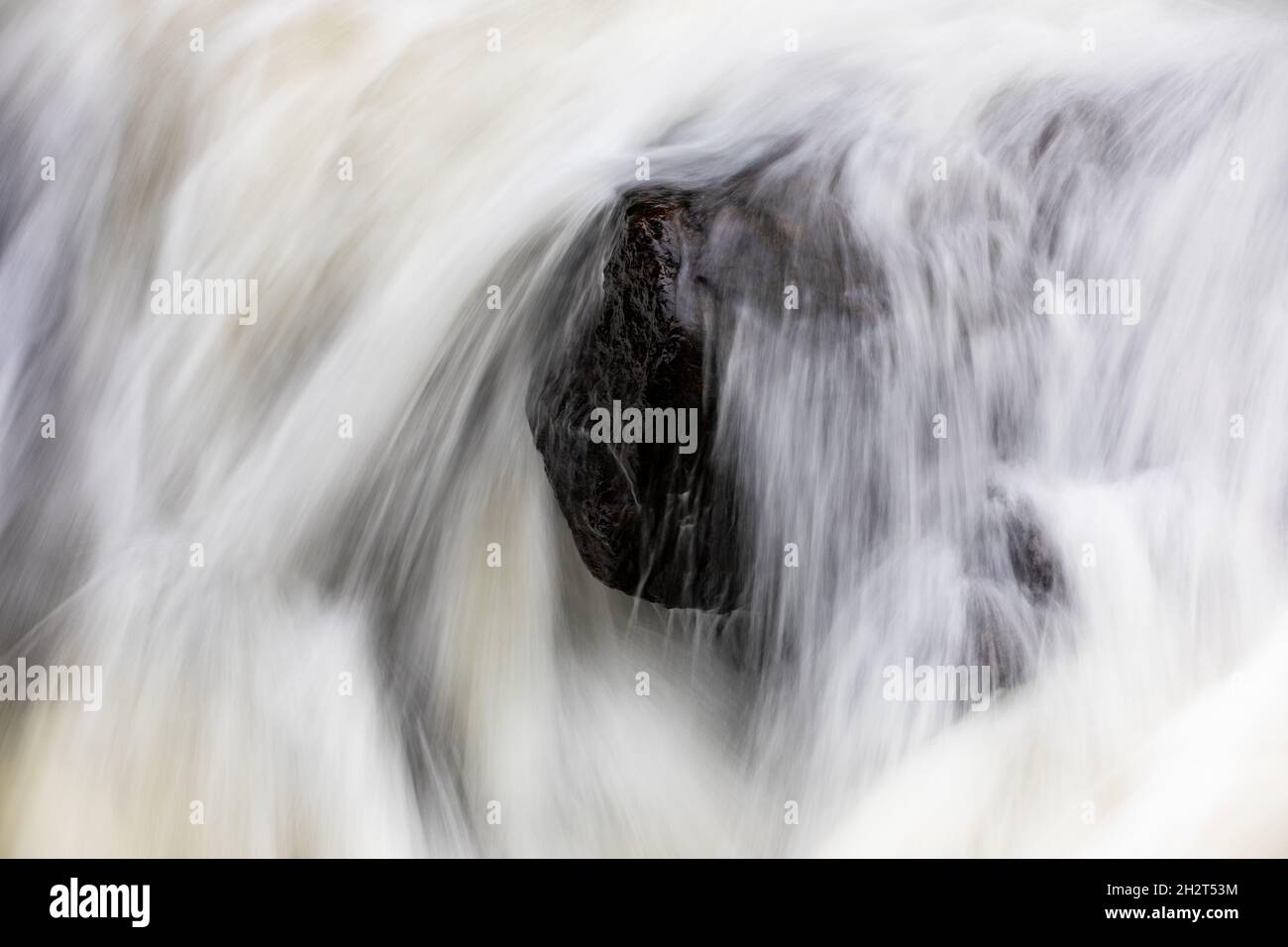 water flowing over black rock Stock Photo - Alamy