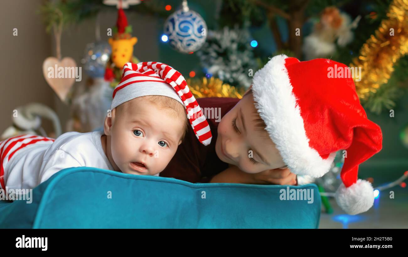 Cute baby with his older brother against the background of a Christmas ...