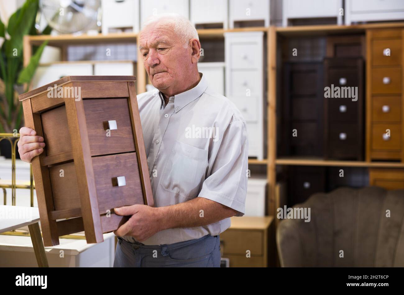 Man choosing small wooden drawer at store Stock Photo - Alamy
