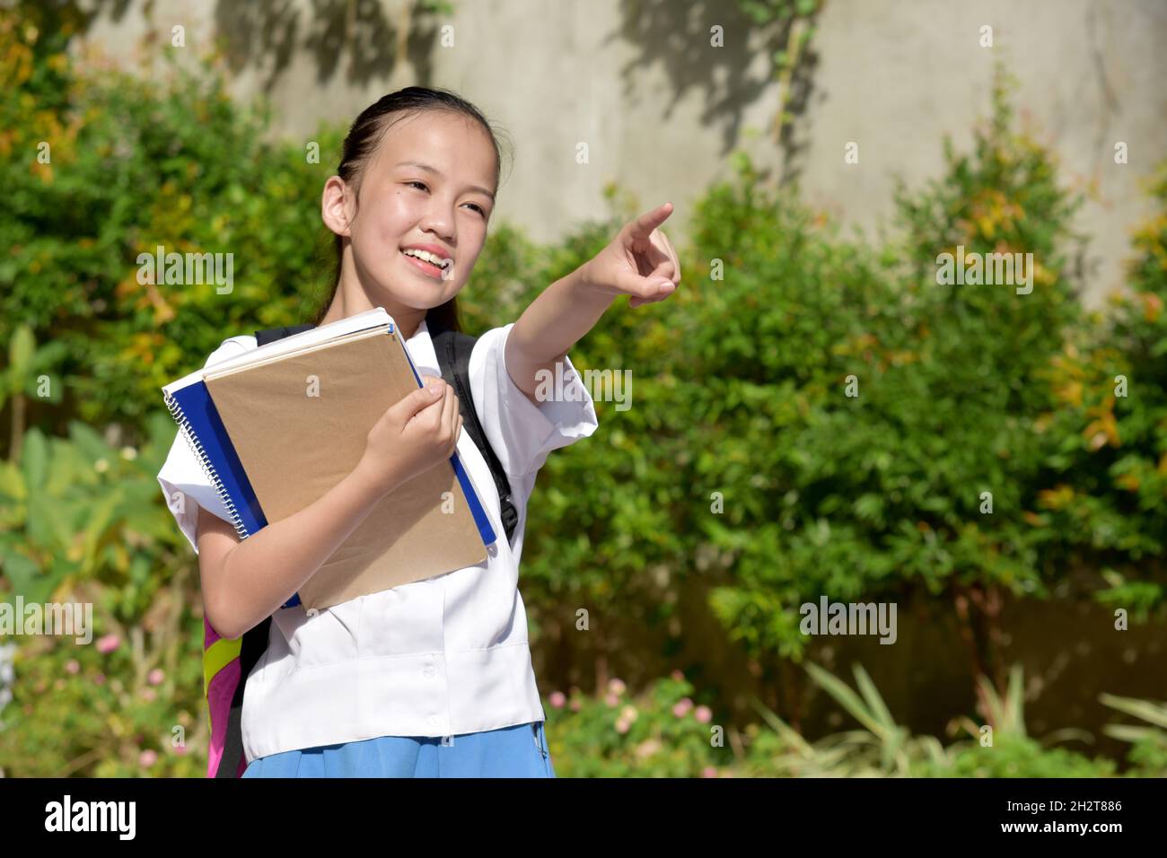 Minority Girl Student Pointing With Notebooks Stock Photo - Alamy