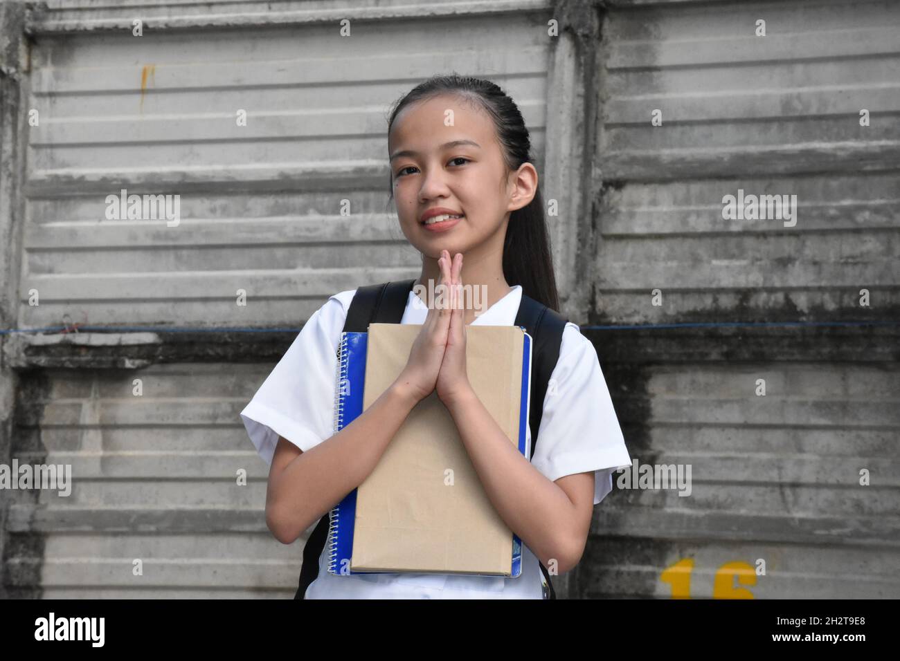 Minority Female Student Praying With Books Stock Photo - Alamy