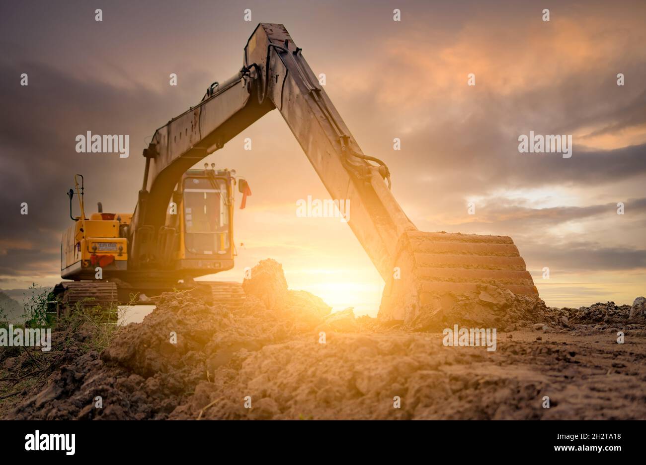 Backhoe parked at construction site after digging soil. Bulldozer on ...