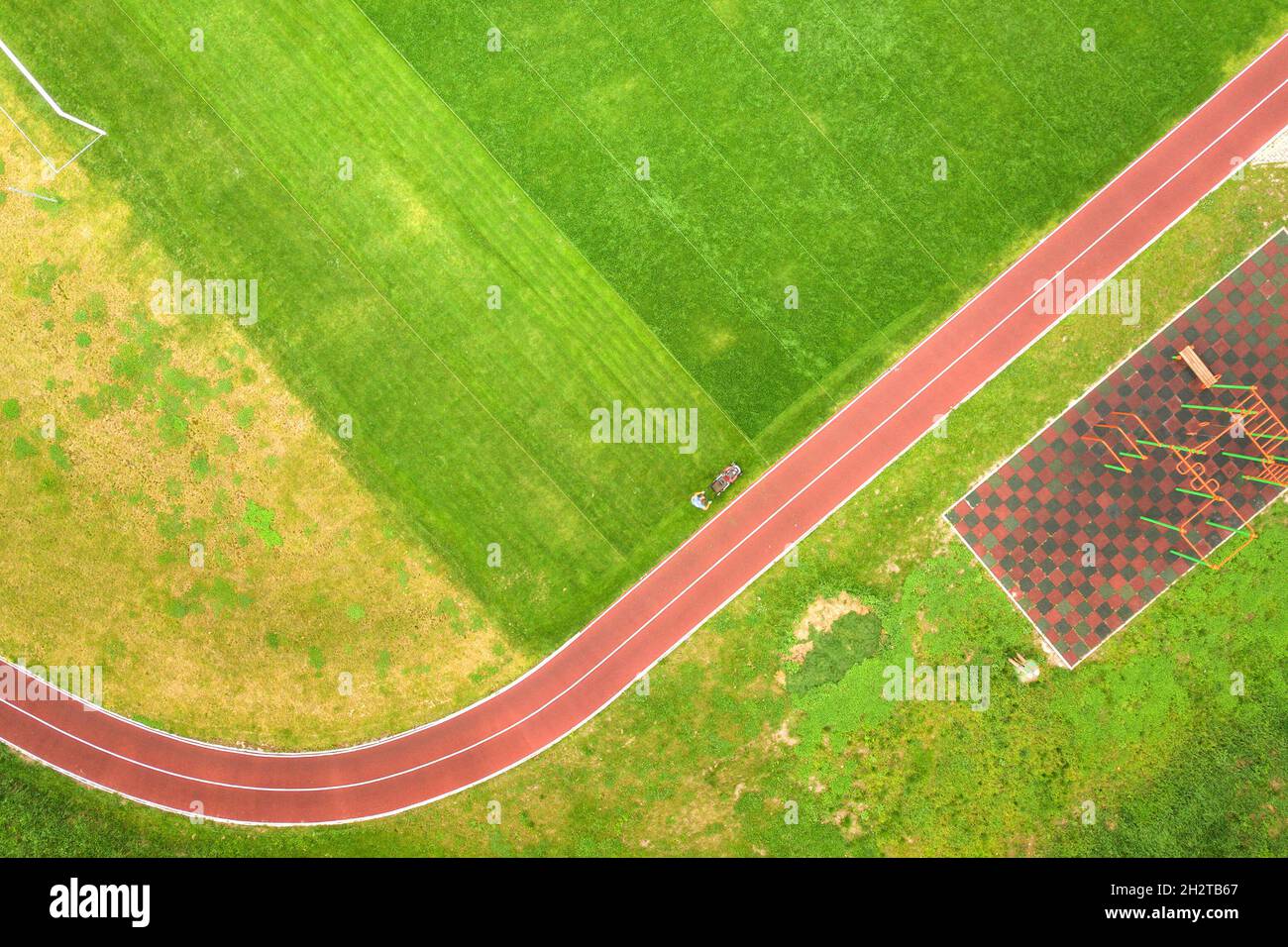Aerial view of sports stadium with red running tracks and green grass ...