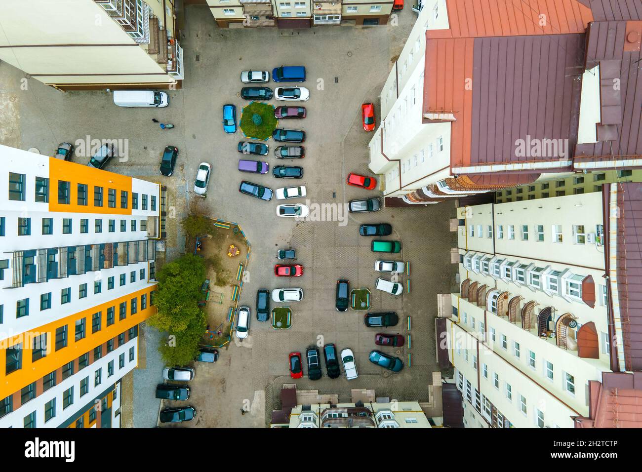 Aerial view of parked cars on parking lot between high apartment ...