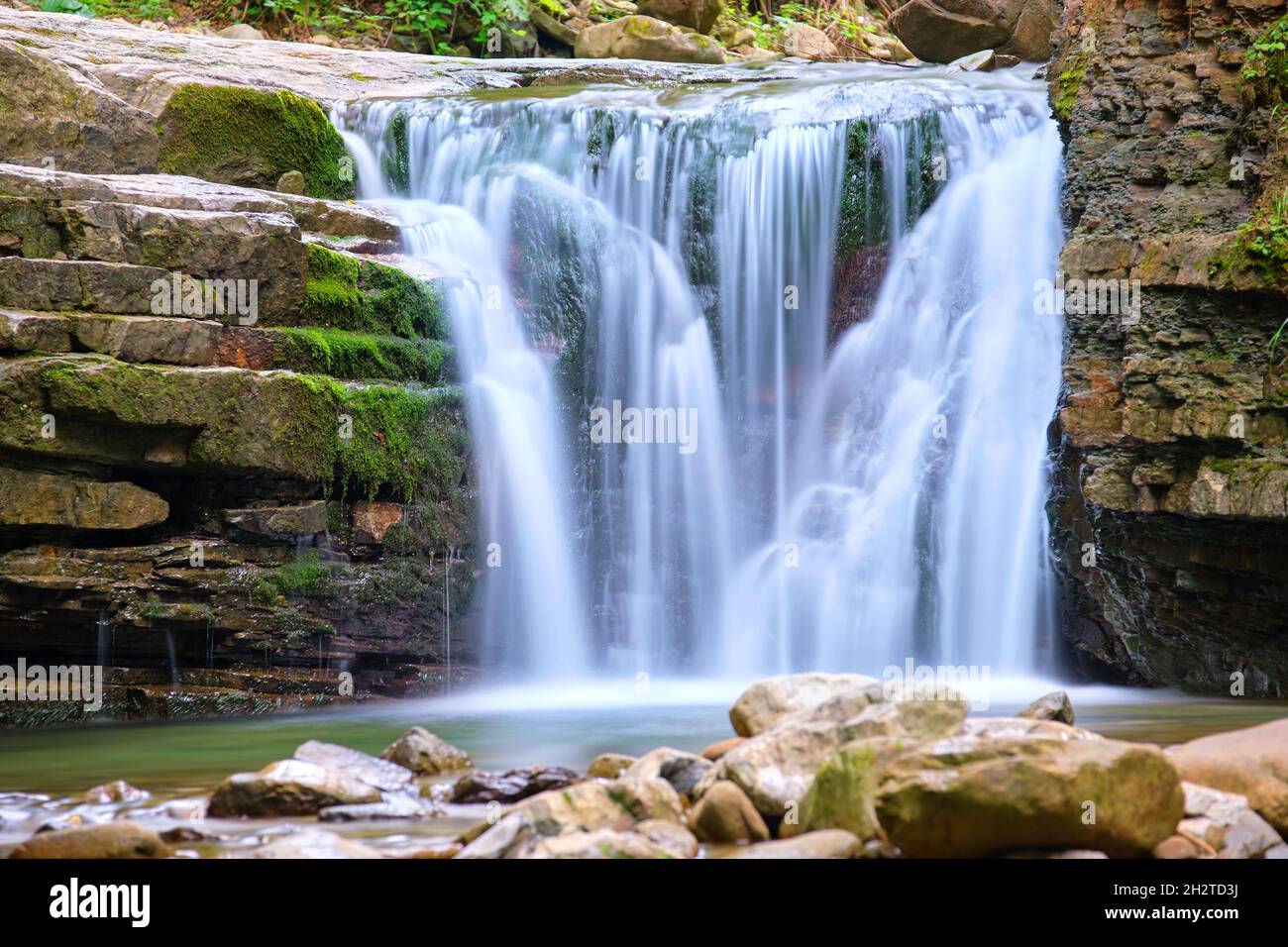 Waterfall on mountain river with white foamy water falling down from ...