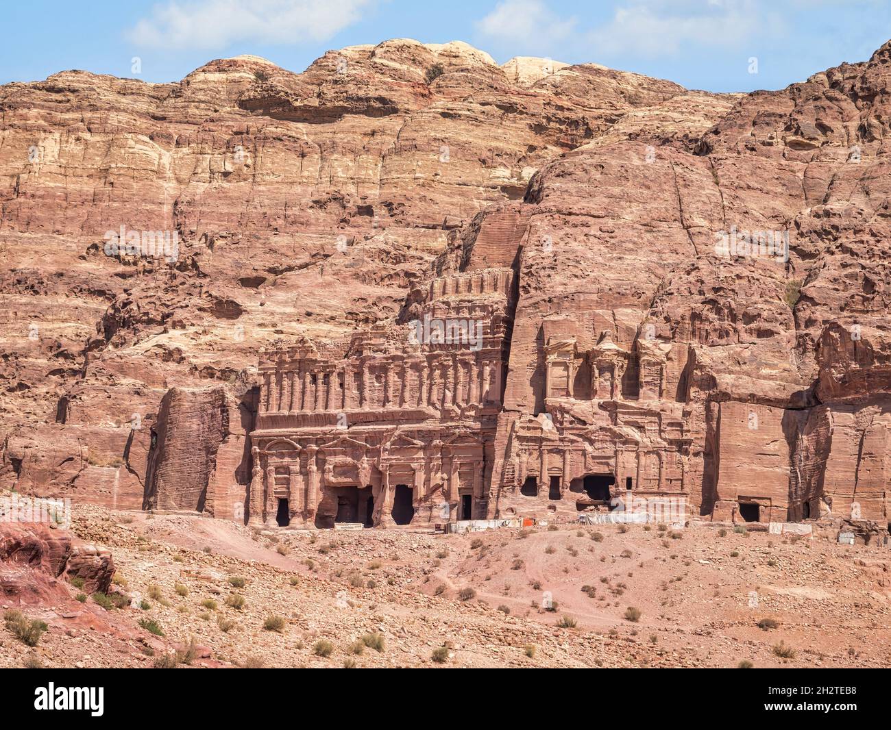 Tomb or housing carved in red rock sand stone. Landscape with a massive ...