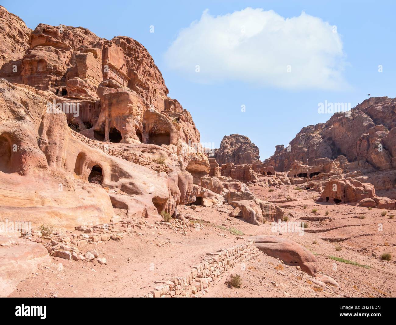 Ancient housing carved in red sand rock in the city of Petra, Jordan ...