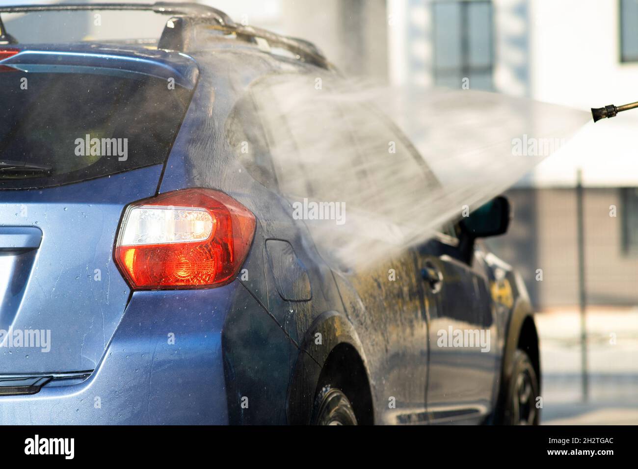 Closeup of male driver washing his car with contactless high pressure ...