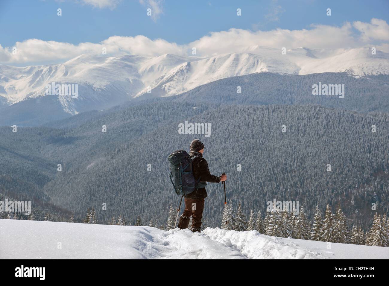 Man backpacker hiking snowy mountain hillside on cold winter day Stock ...