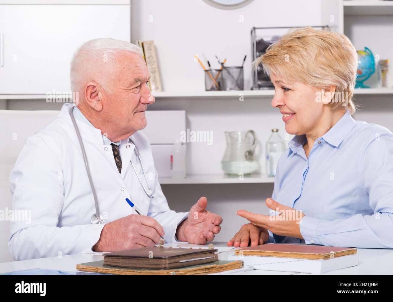 Male doctor with female client Stock Photo - Alamy