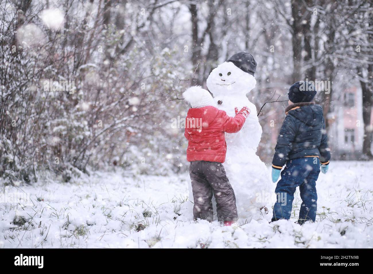 Kids walk in the park with first snow Stock Photo - Alamy