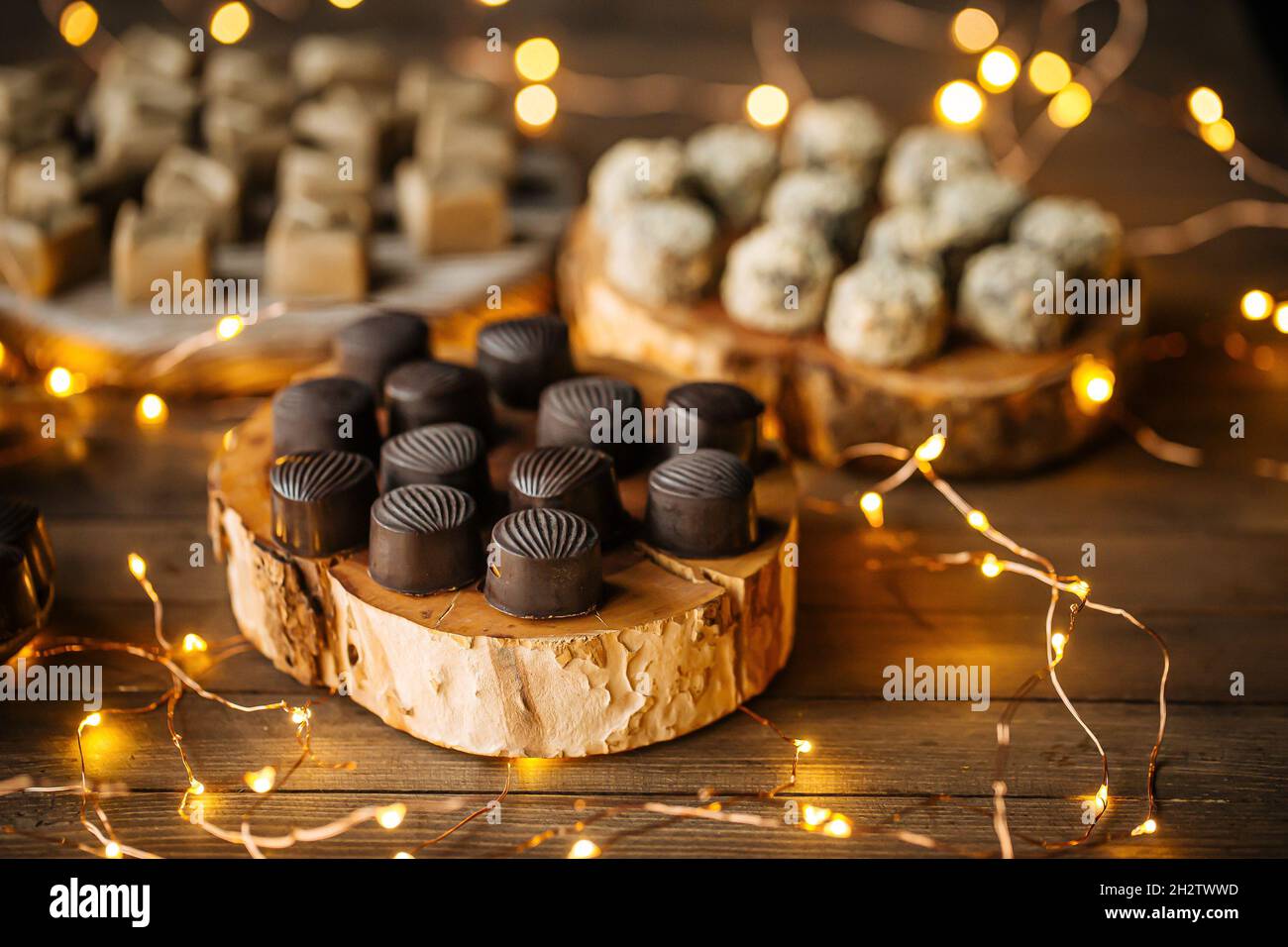 Assorted chocolates on wooden table with garland Stock Photo - Alamy