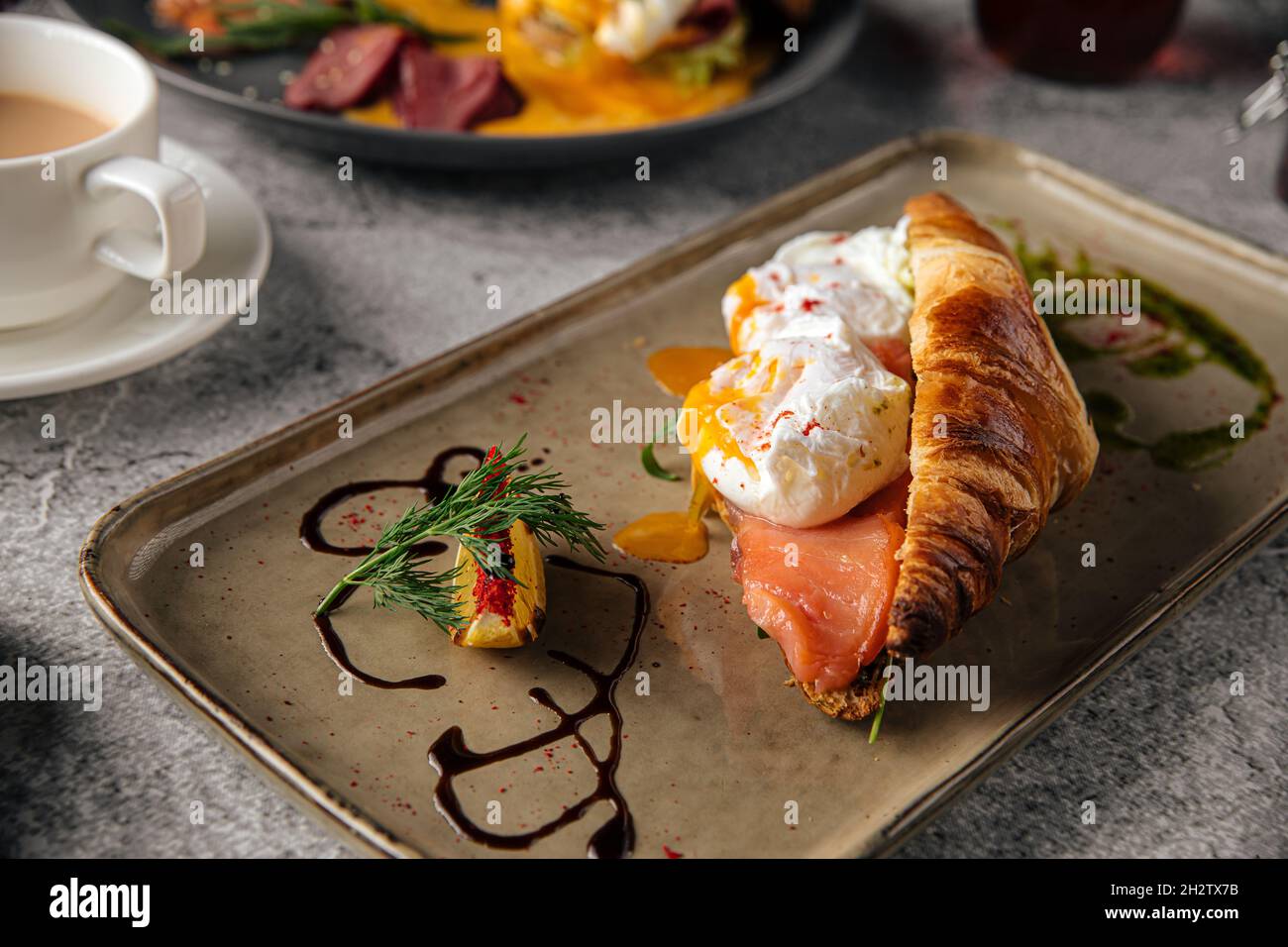 Croissant with poached egg and salmon breakfast Stock Photo - Alamy