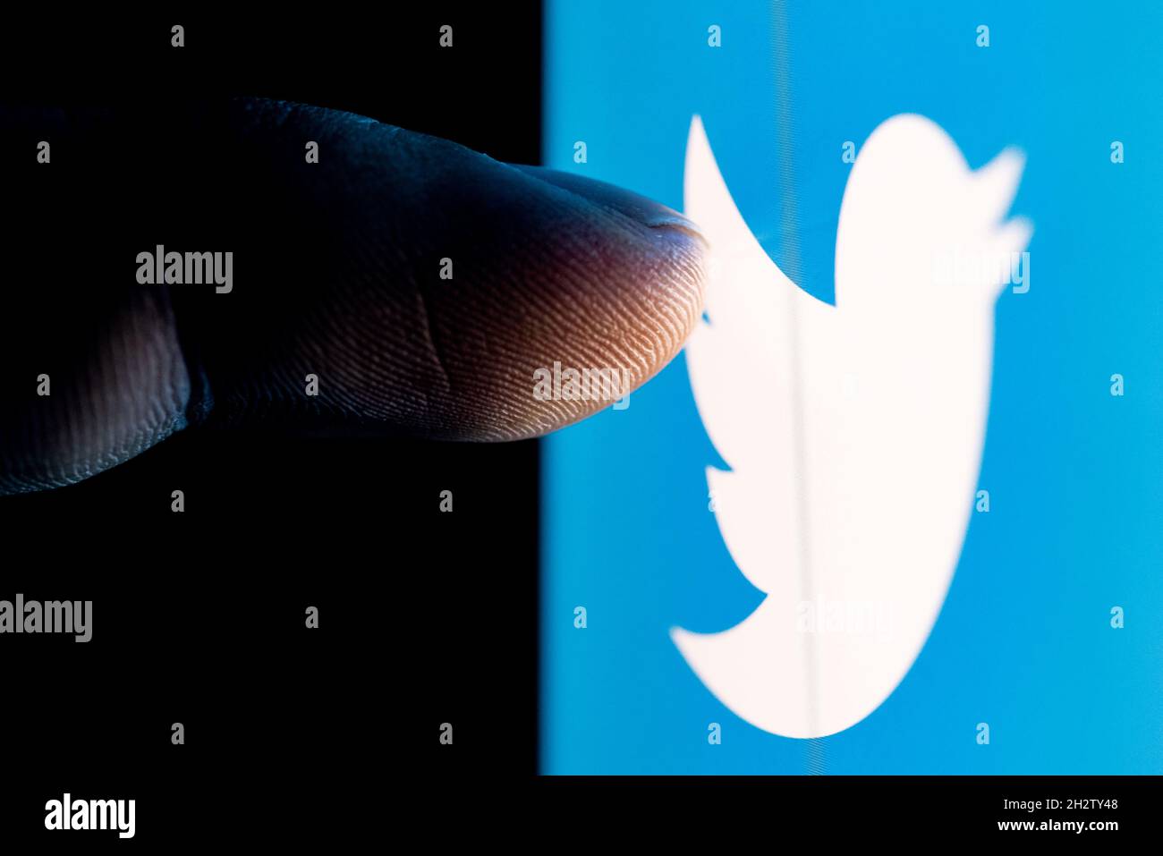 The finger reaches for the Twitter social network logo on the ...