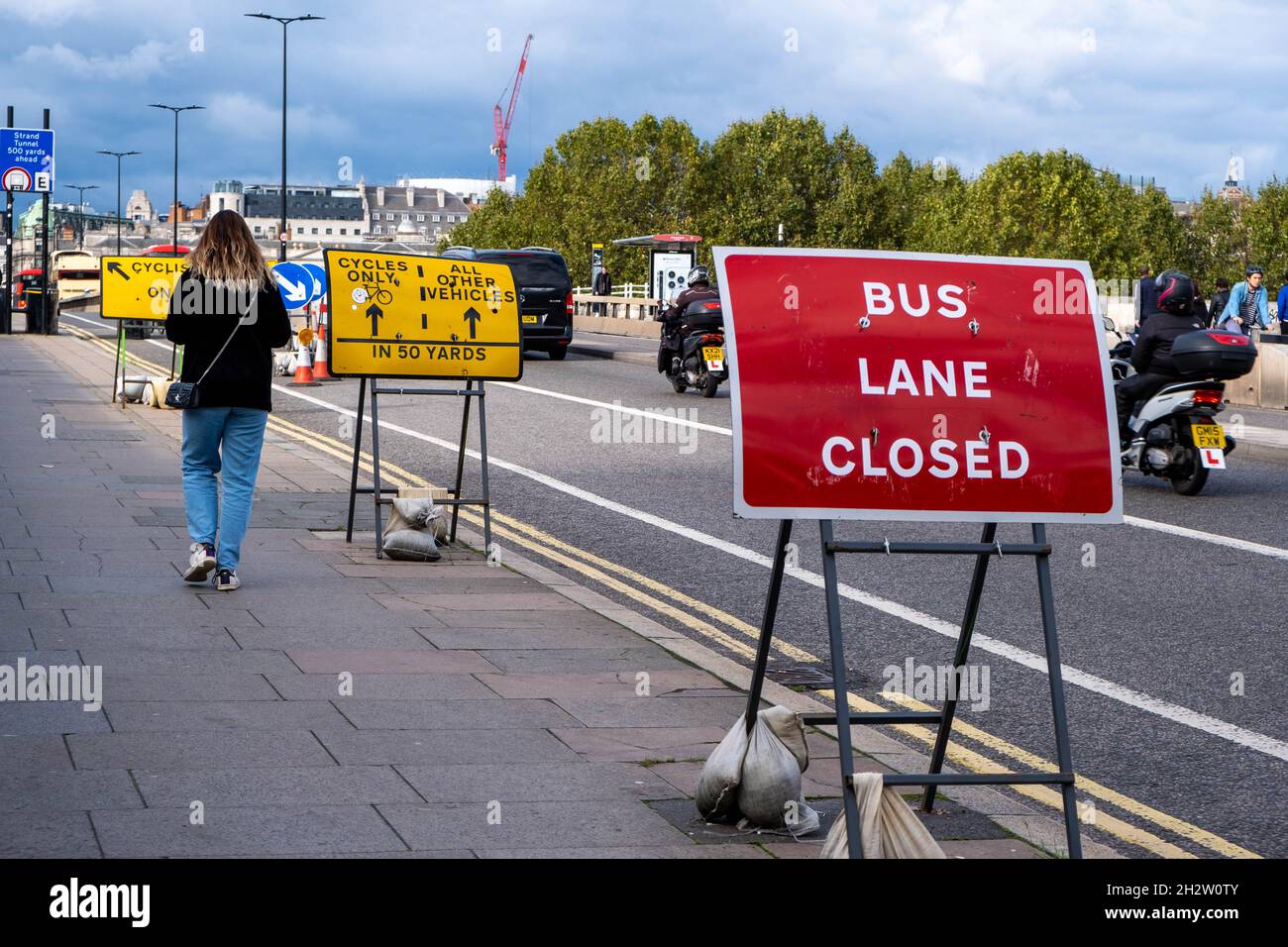 Woman walking past traffic signs hi-res stock photography and images ...