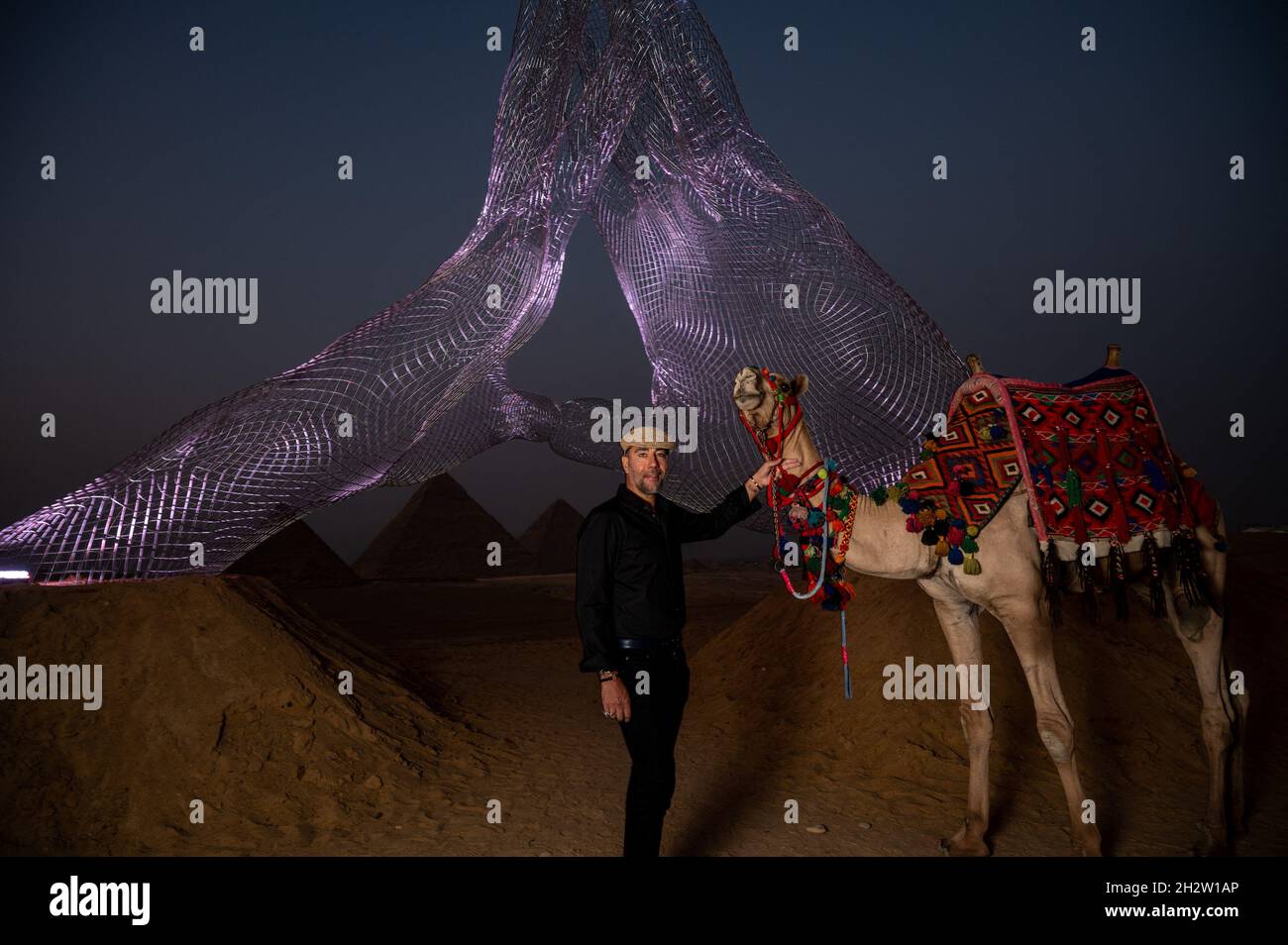 Italian artist Lorenzo Quinn poses next to his installation entitled ...