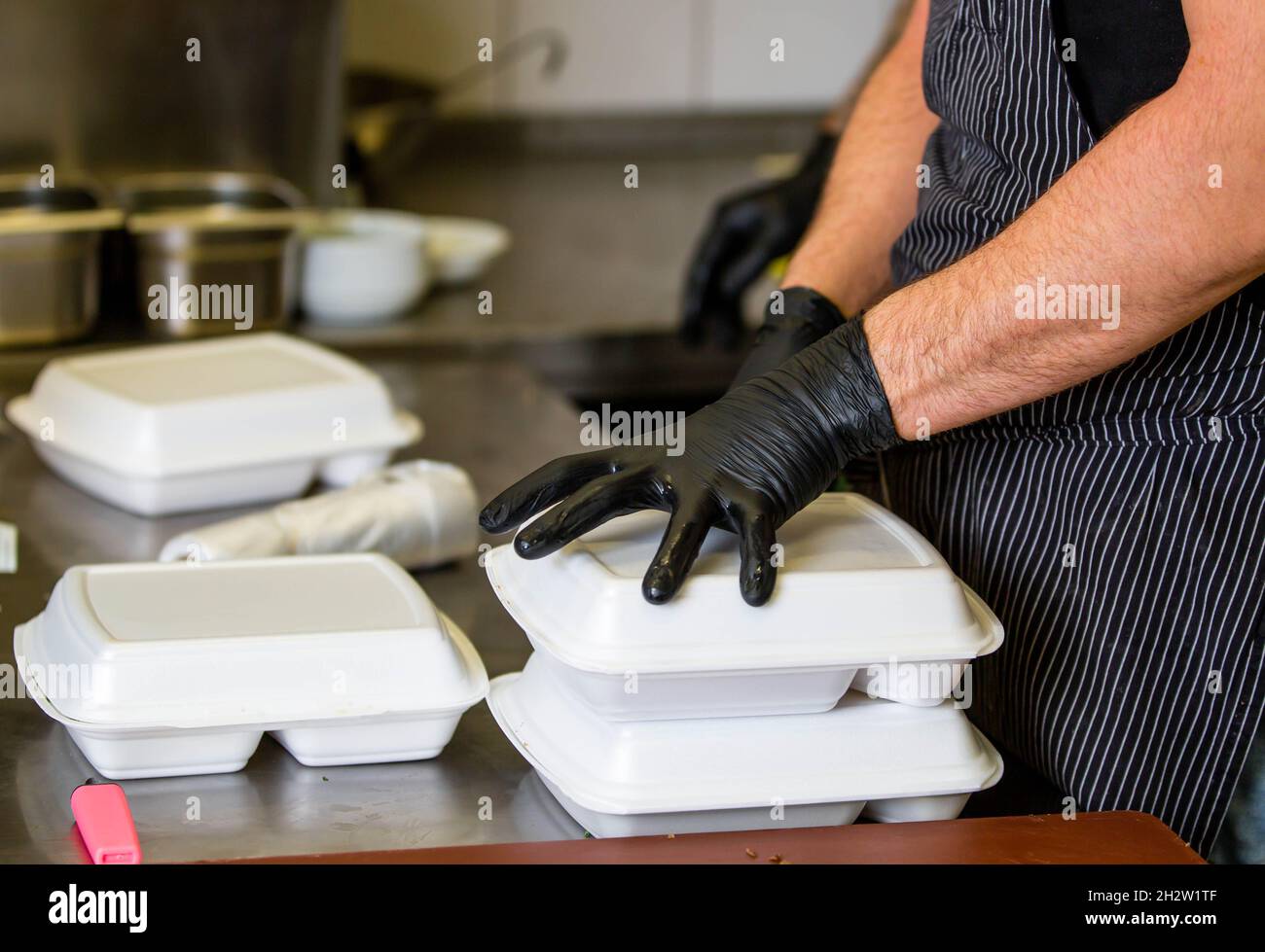Chef preparing takeaway dish in the restaurant or pub , food delivery ...