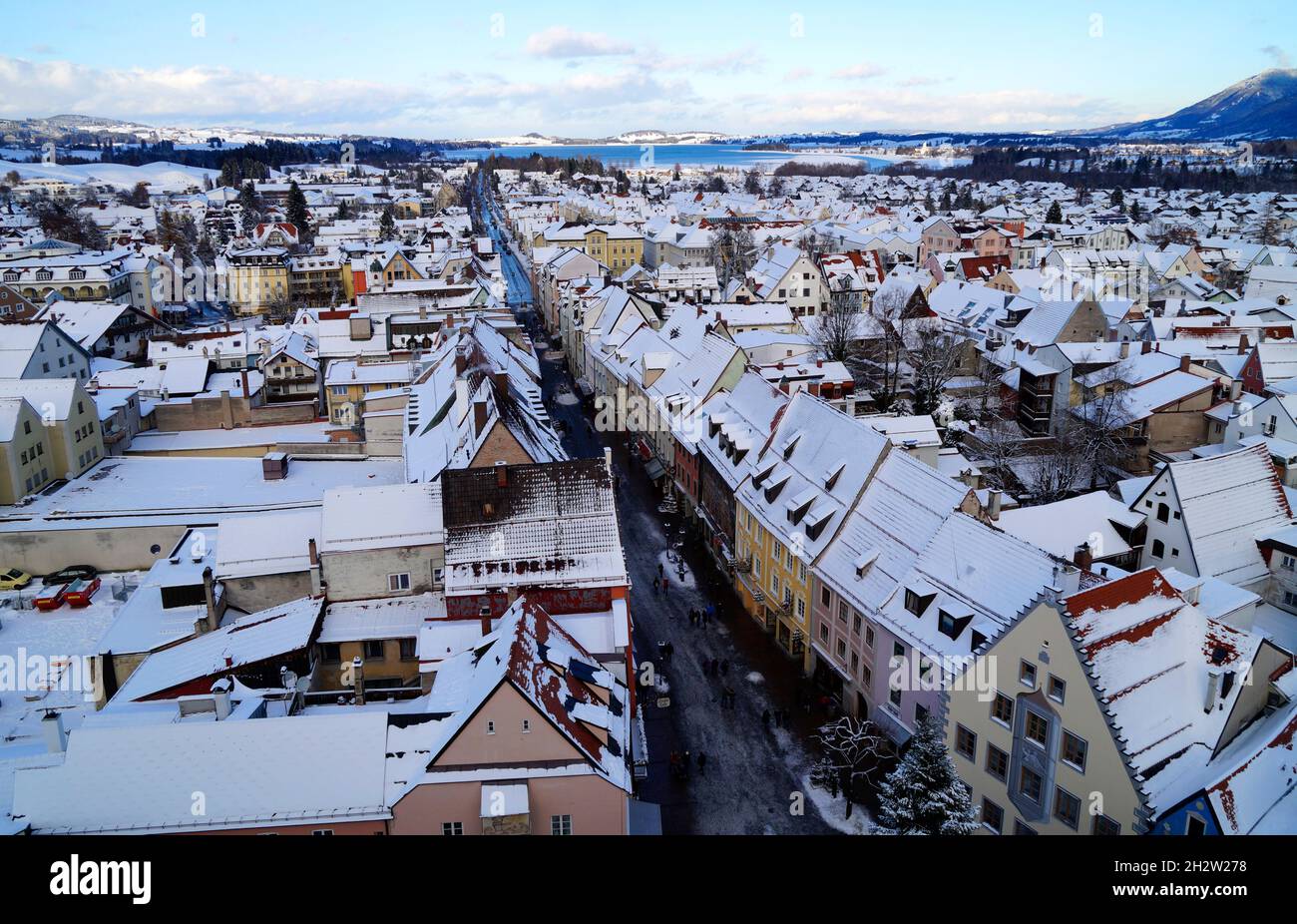 over the wintery Fuessen covered with snow with lake Forggensee and the ...