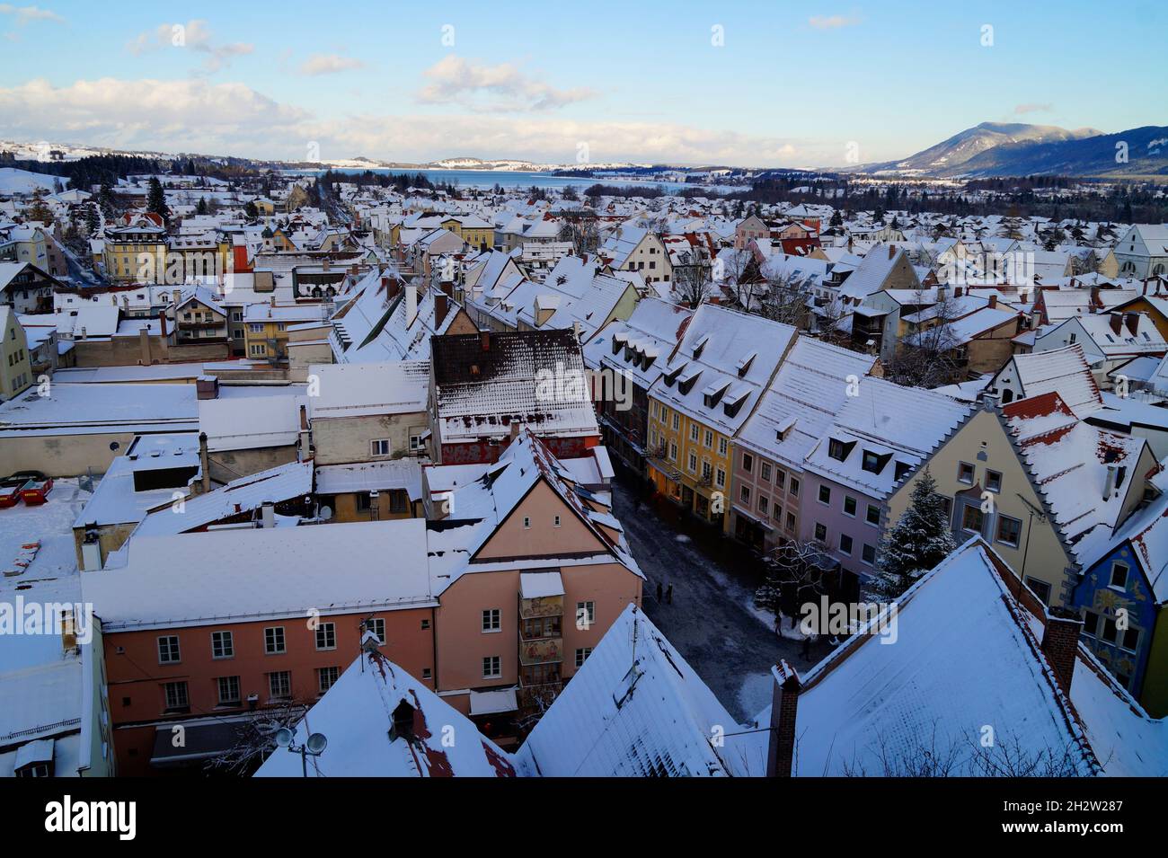 over the wintery Fuessen covered with snow with lake Forggensee and the ...