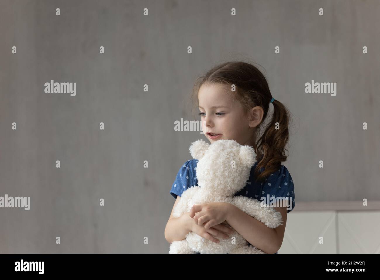 Happy adorable little kid girl cuddling favorite fluffy teddy bear ...