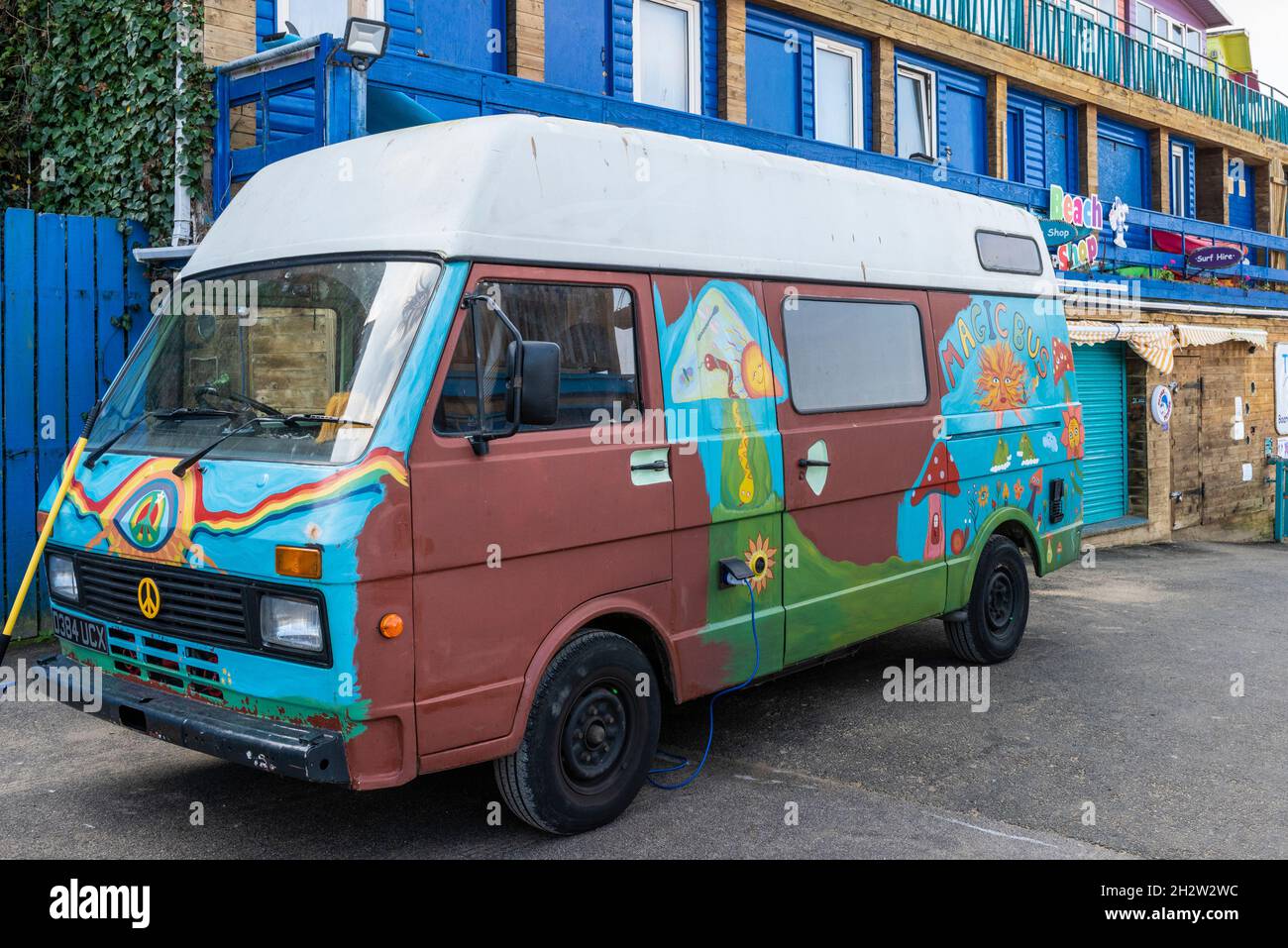 A handpainted scruffy colourful camper van parked at Towan beach in ...