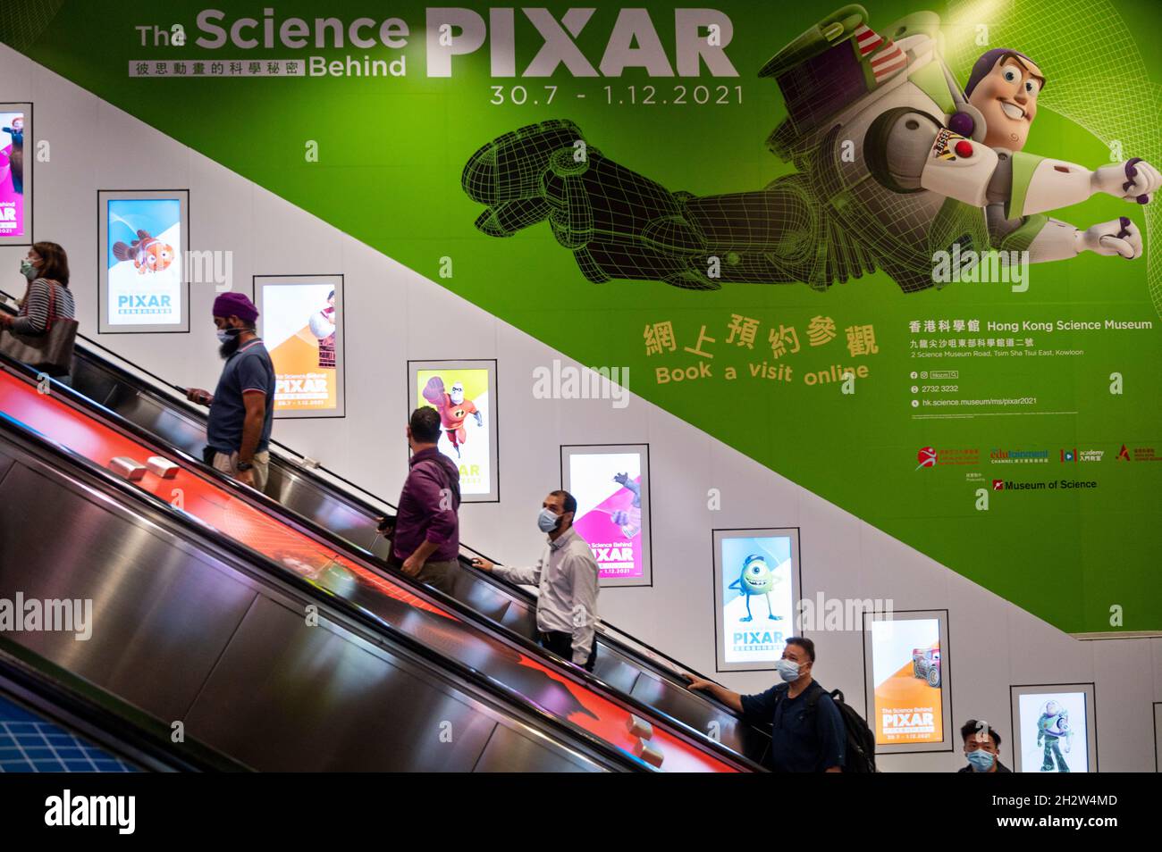 Commuters are seen riding on an escalator as they pass by an ...
