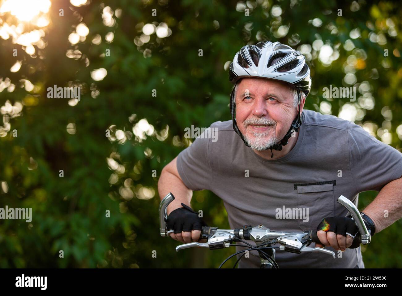 Elderly man riding bicycle bike ride exercise park cycle hi-res stock ...