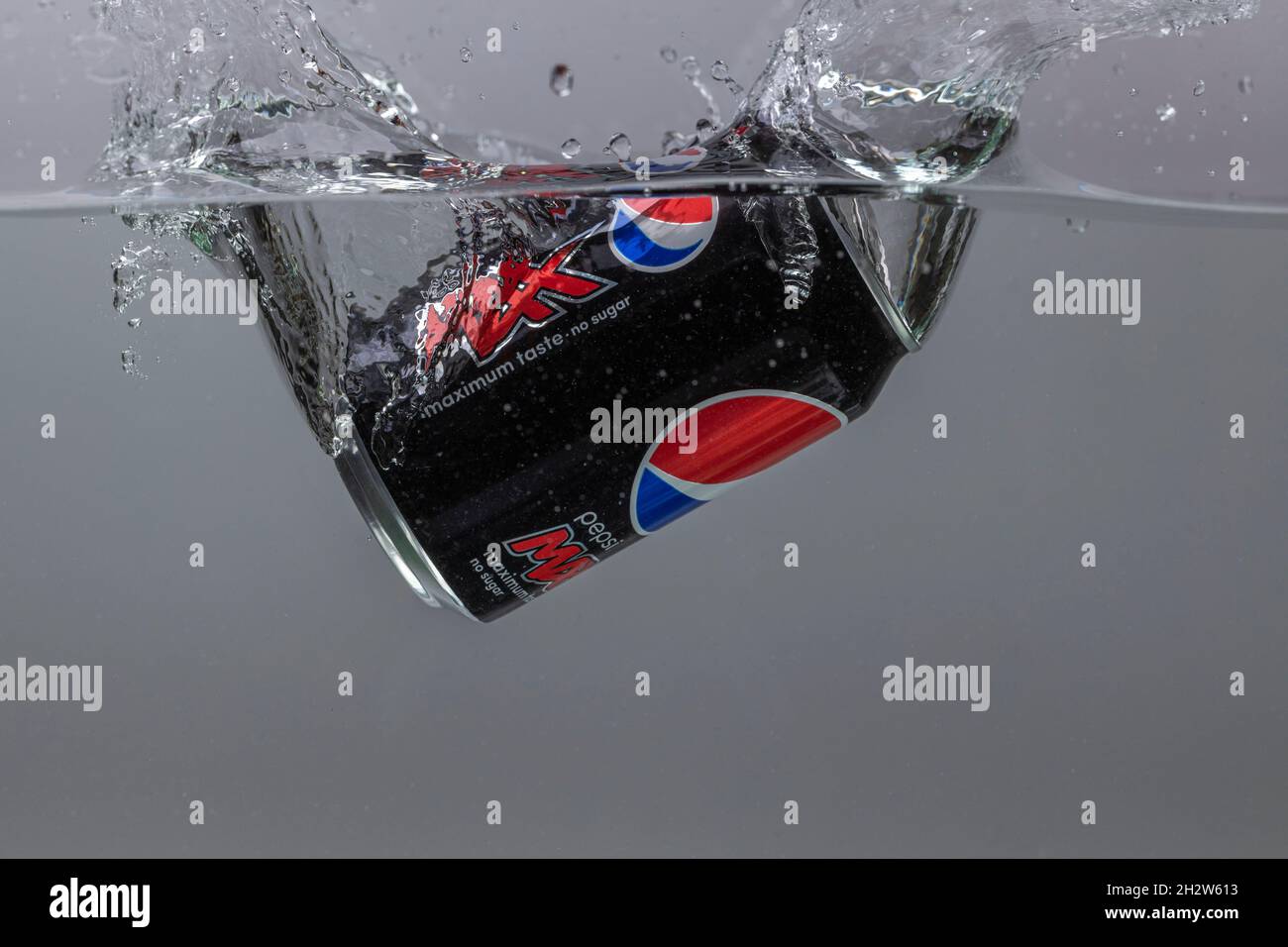 Close up view of can of Pepsi cola falling into water isolation on gray ...