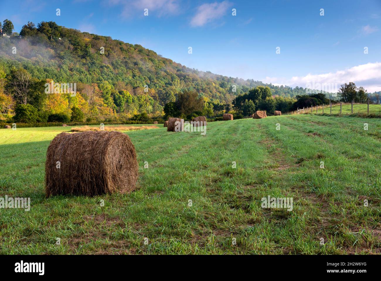 Morning scene of bales of hay with a Taconic mountain side backdrop in ...