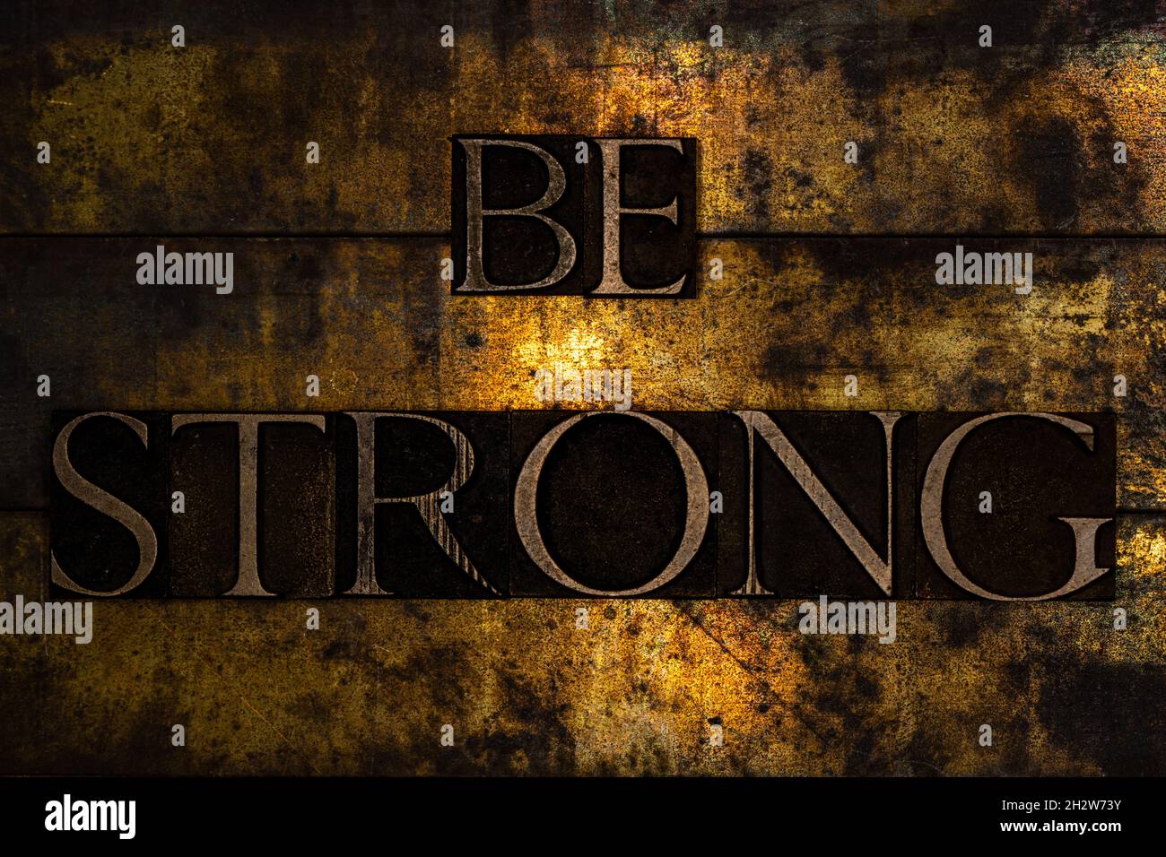 Be Strong text on textured grunge copper and vintage gold background ...