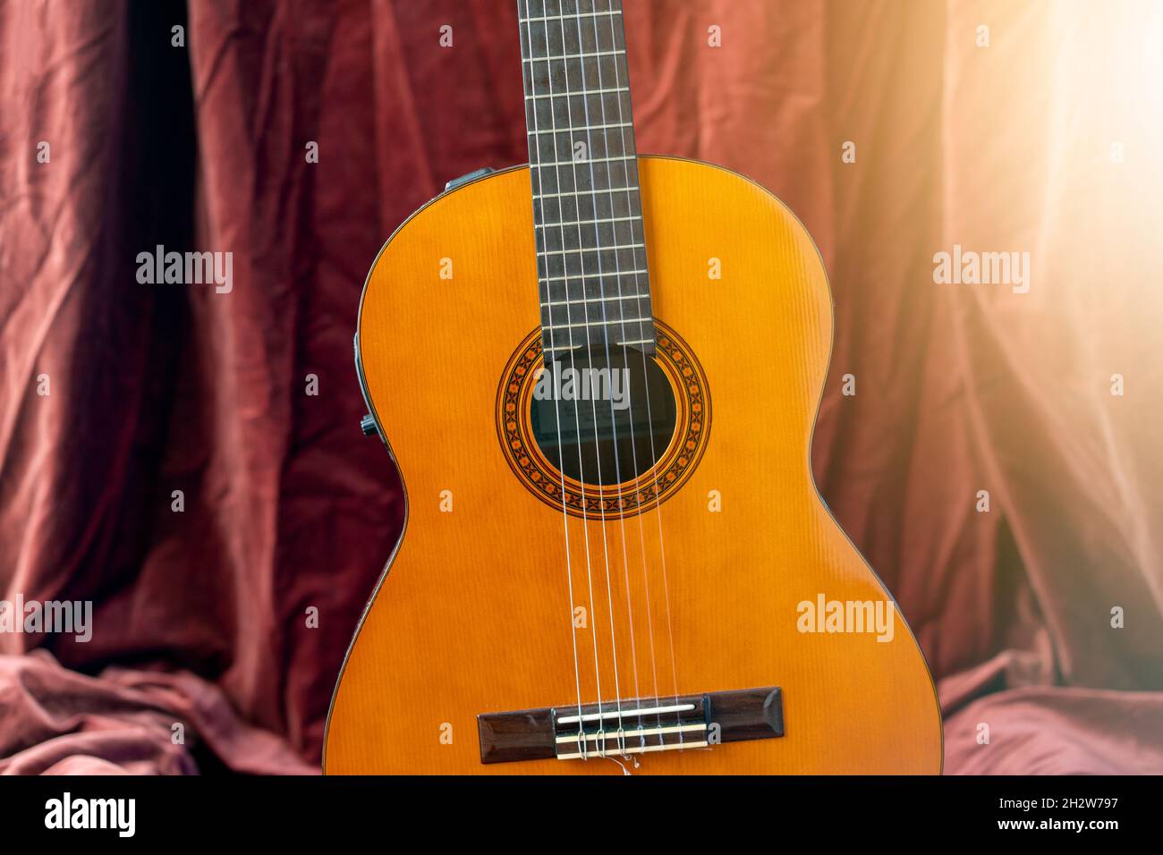 Classic Guitar on red background. Acoustic guitar concept Stock Photo ...