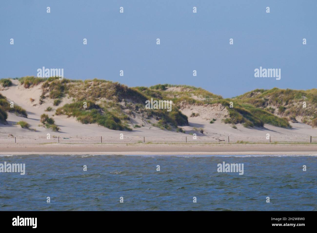 blue waves of the german north sea with the beach and sand dunes ...
