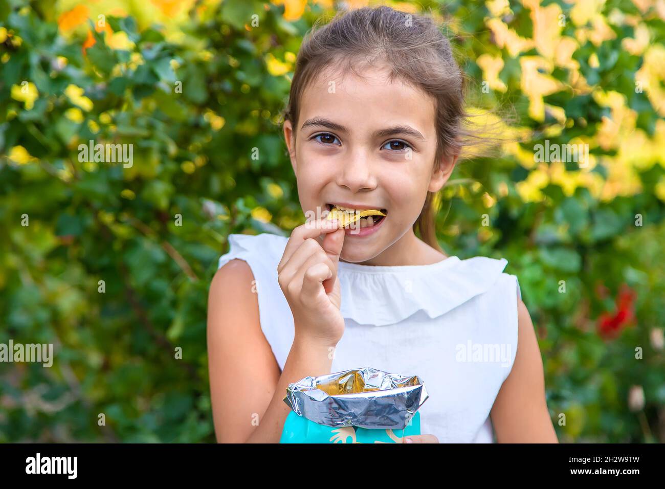 The child is eating chips. Selective focus. Kid Stock Photo - Alamy