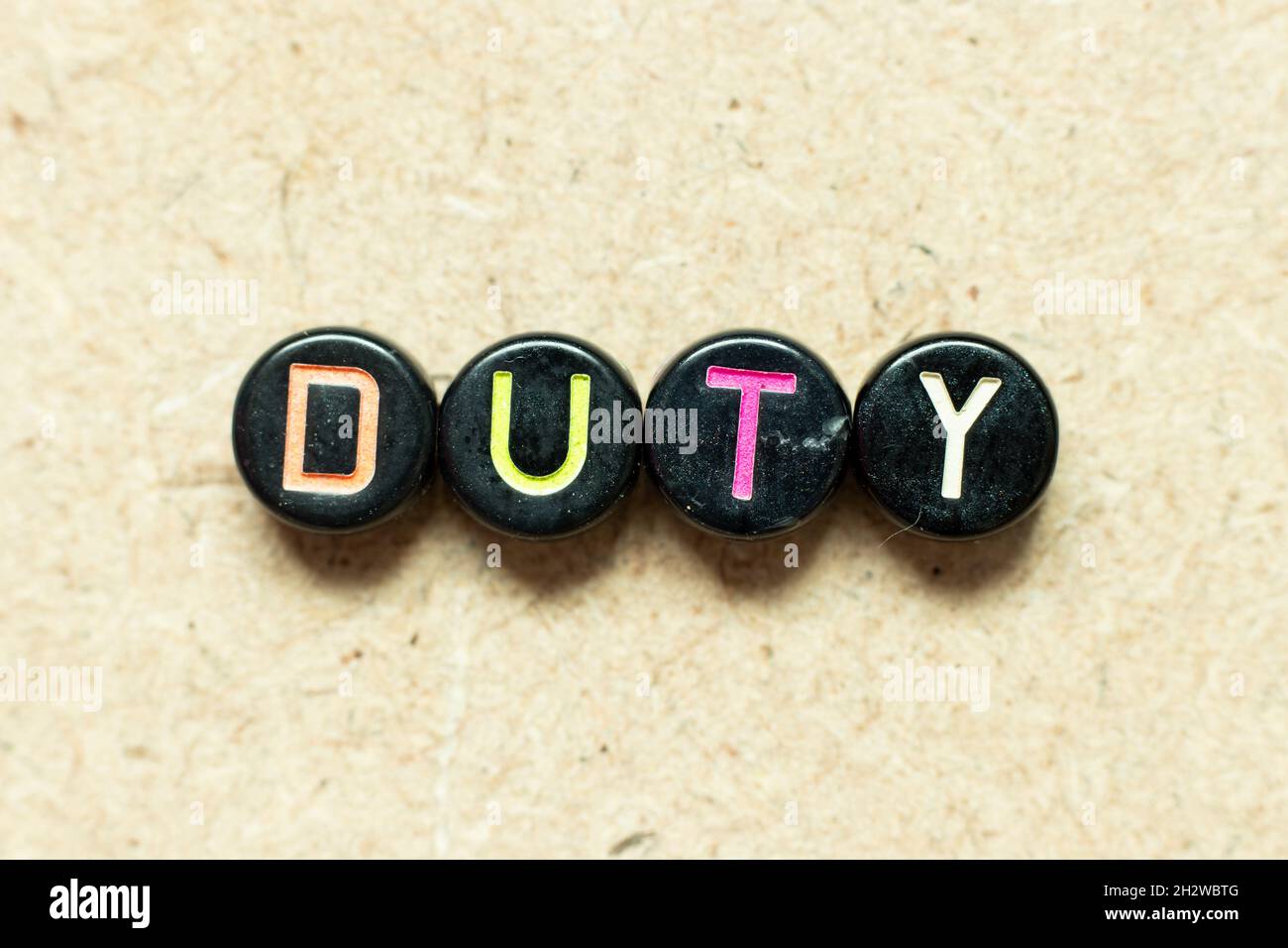 Black color round alphabet letter block in word duty on wood background ...