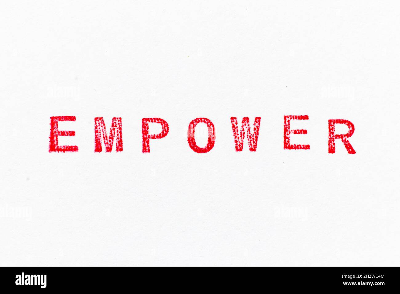 Red color ink rubber stamp in word empower on white paper background ...
