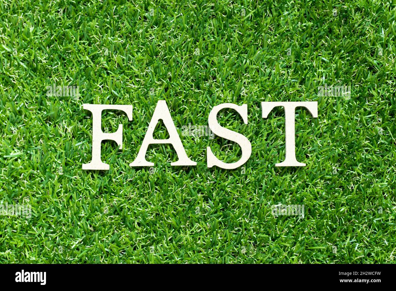 Alphabet letter in word fast on green grass background Stock Photo - Alamy