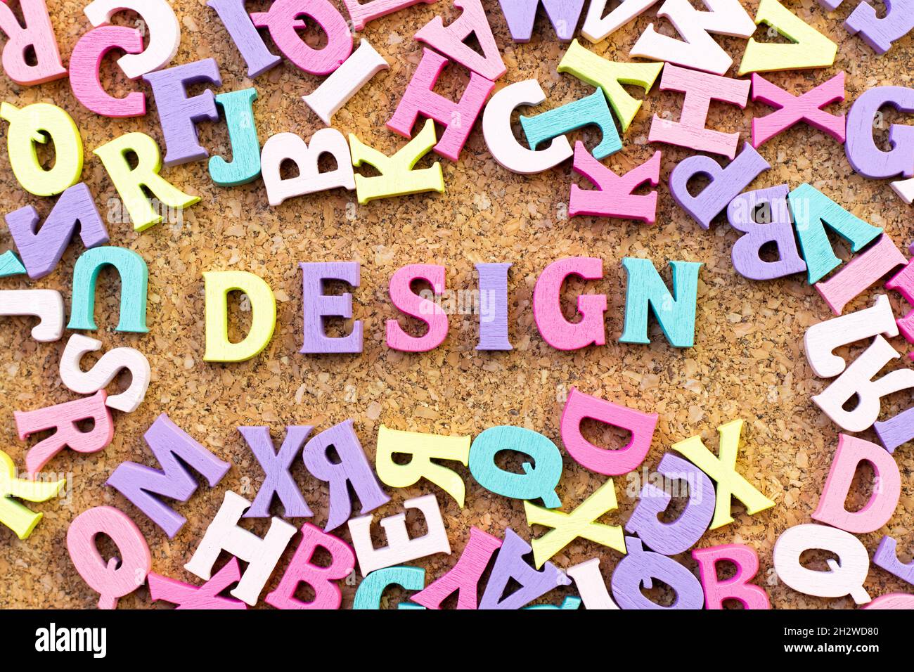 Color alphabet in word design with another letter as frame on cork ...