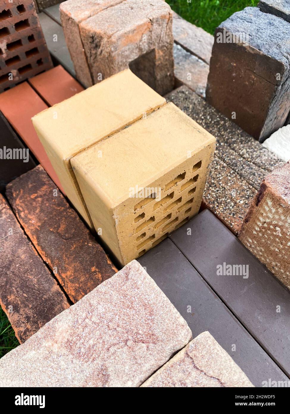 Different types of bricks stacked beautifully on green grass Stock ...