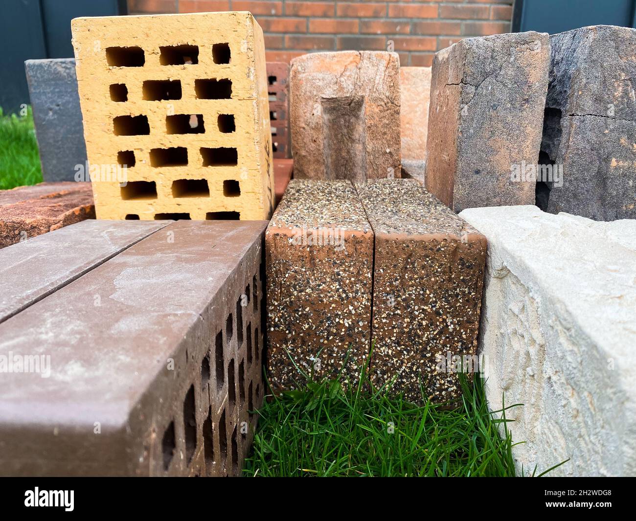 Different types of bricks stacked beautifully on green grass Stock ...