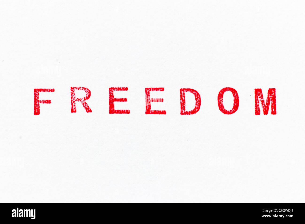 Red color ink rubber stamp in word freedom on white paper background ...