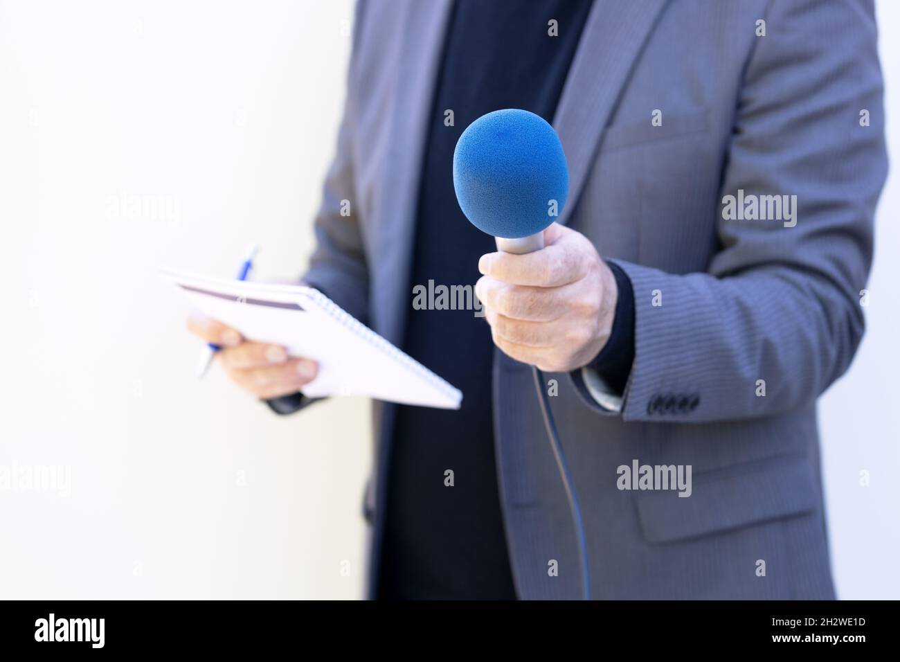 Reporter holding microphone making media interview Stock Photo - Alamy