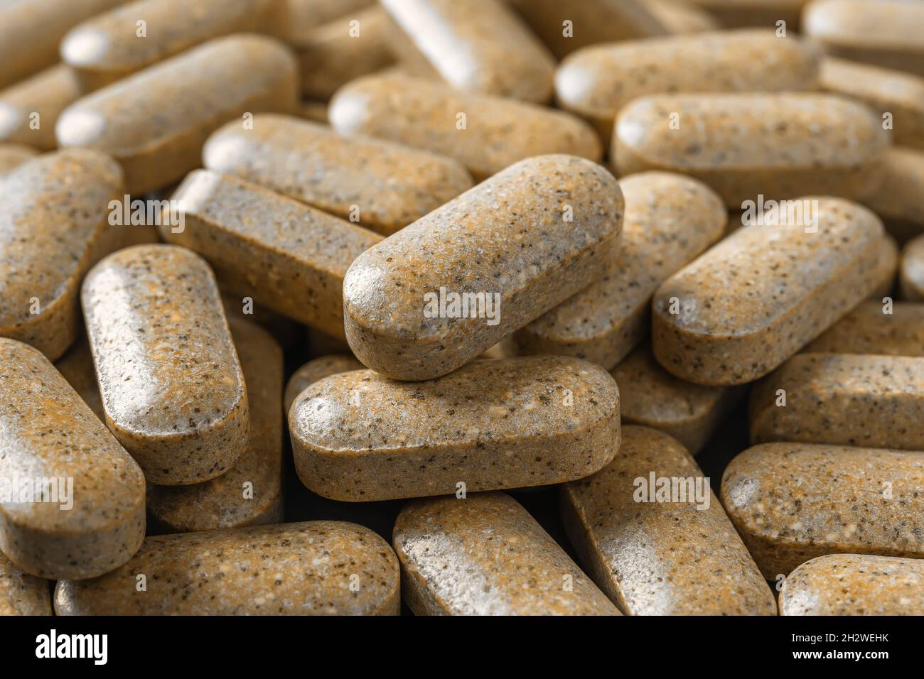 Pile of daily multyvitamin pills macro texture. Everyday herbal brown ...
