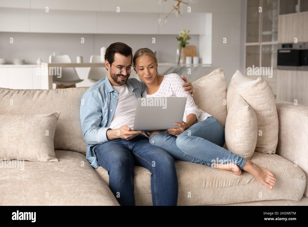 Happy loving young family couple using computer at home Stock Photo - Alamy