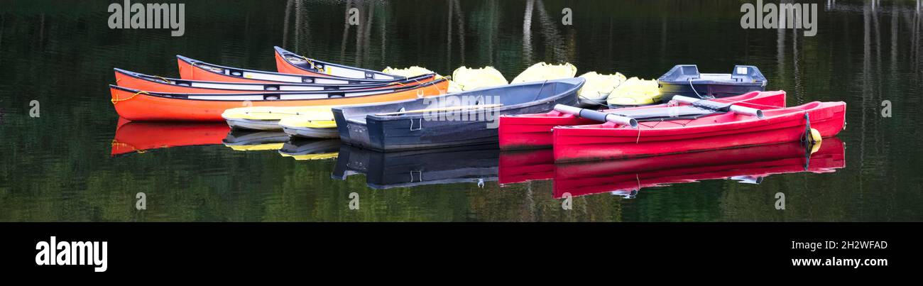 Red blue and yellow kayak canoes in row moored at lake Stock Photo - Alamy