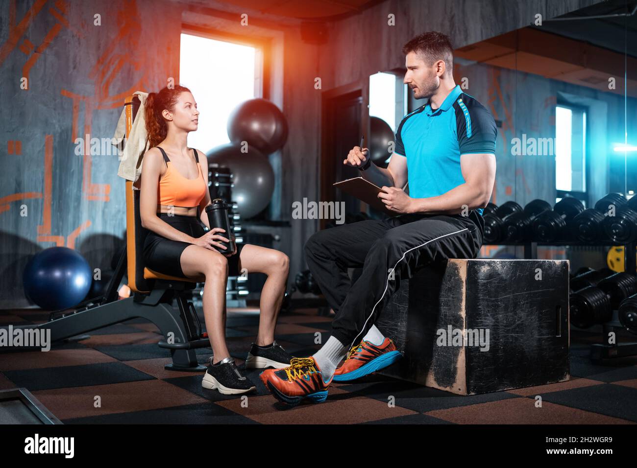 young personal trainer man talking with woman athlete and plan workout ...