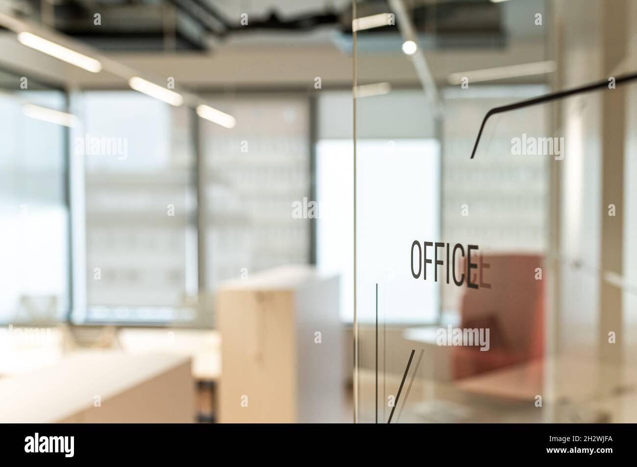 Glass transparent open door in the office with the inscription OFFICE ...