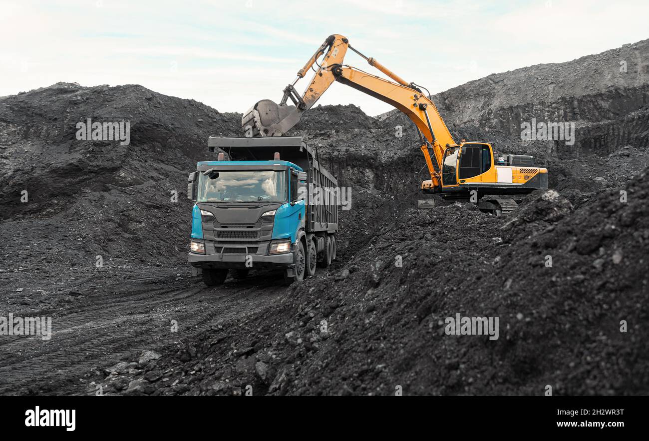Large quarry dump truck. Loading the rock in dumper. Loading coal into body truck. Production ...